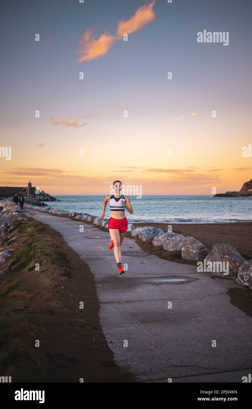 Woman running on a beautiful path with a sunset Stock Photo - Alamy