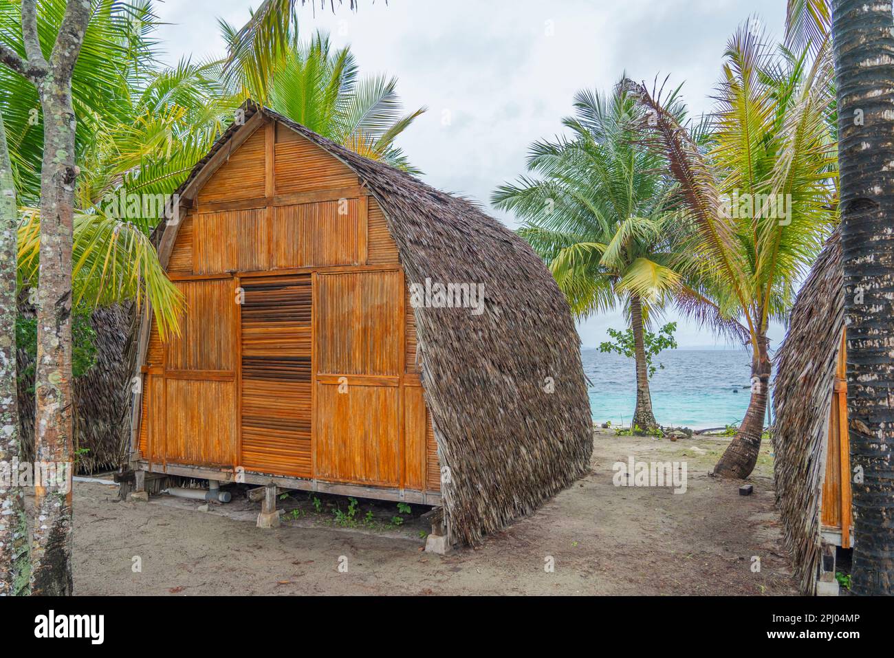 Small traditionally built bamboo huts among palm trees on Fam Island ...