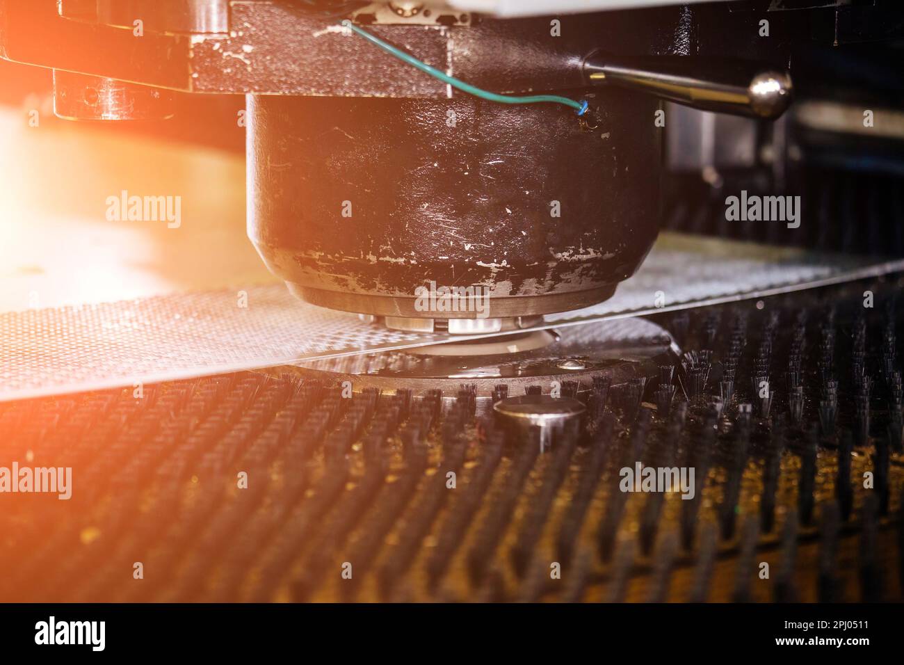 CNC punching and nibbling machine and perforated steel sheet, close up ...
