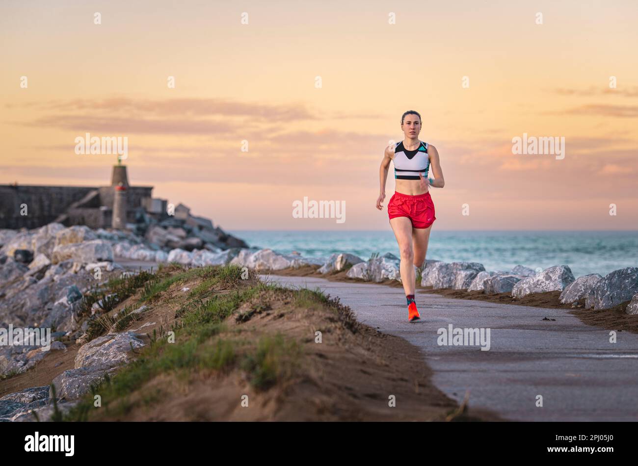 Woman running on a beautiful path with a sunset Stock Photo - Alamy