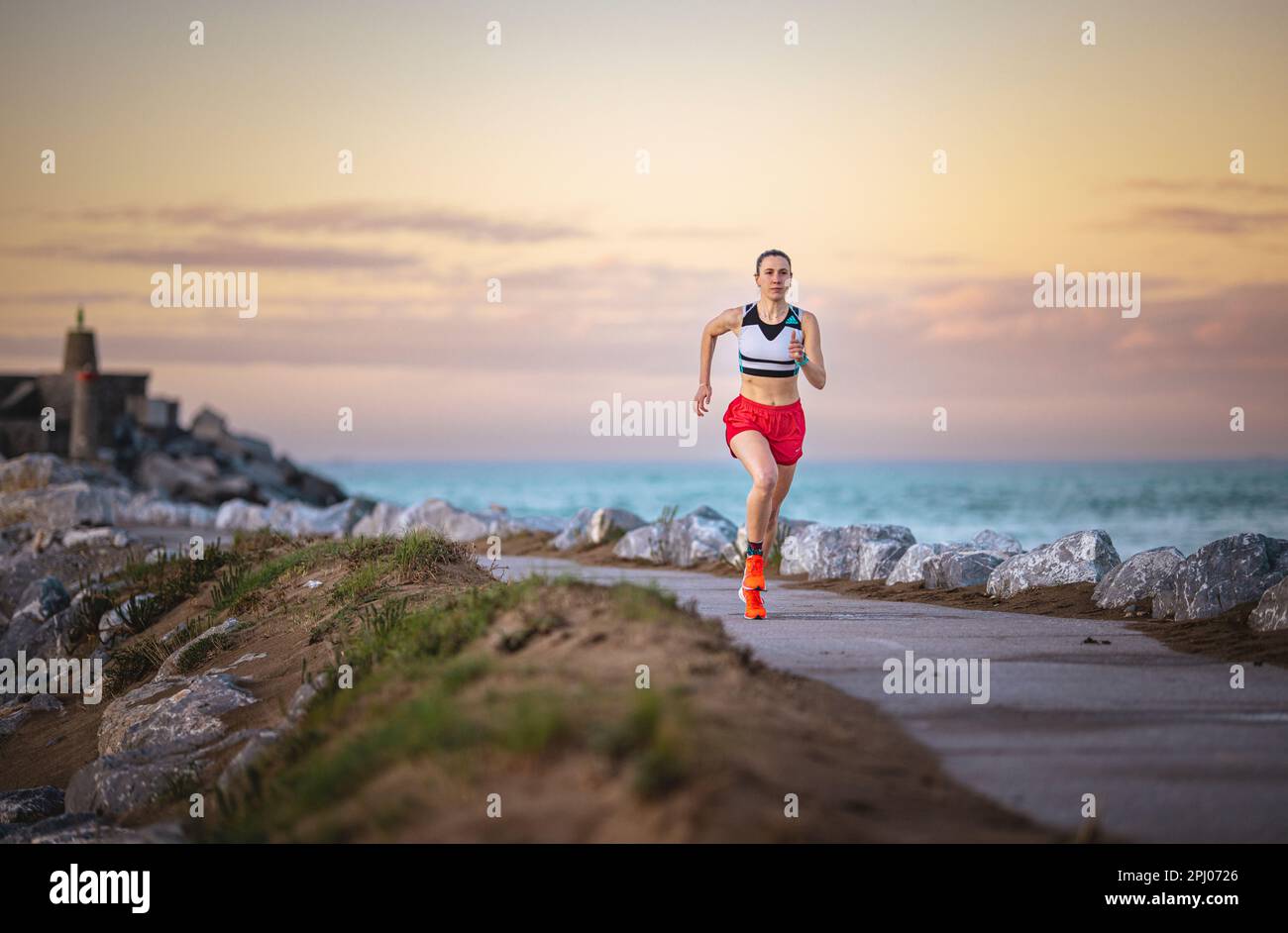 Woman running on a beautiful path with a sunset Stock Photo - Alamy