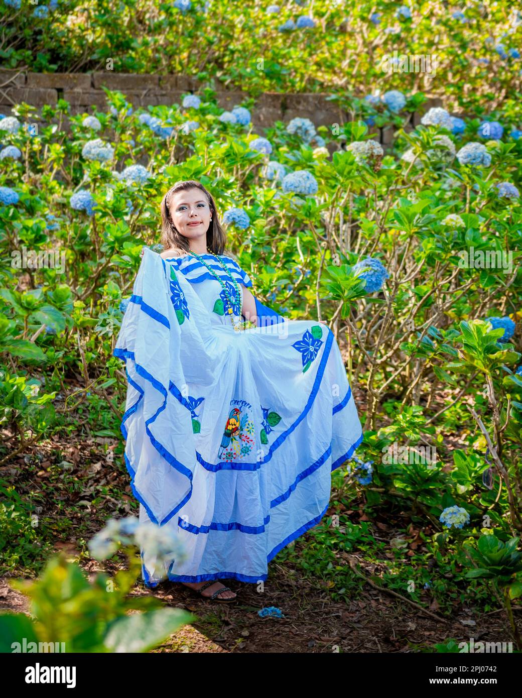 Nicaraguan woman in traditional folk costume in a field of flowers ...