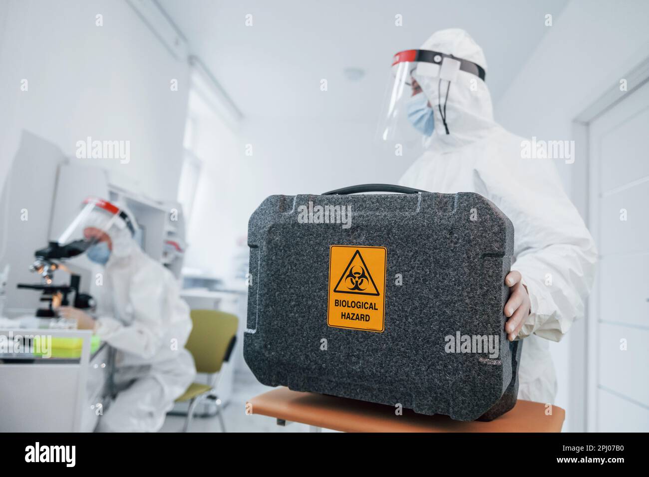 With biological hazard case. Female medical workers in protective ...