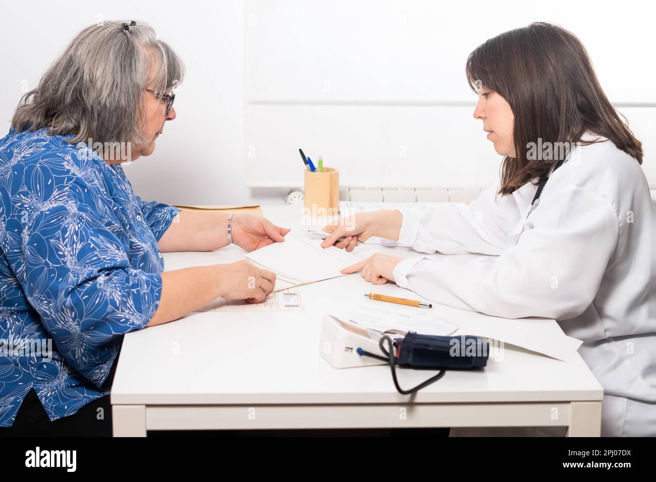 Young female doctor explaining to her elderly patient the results of ...