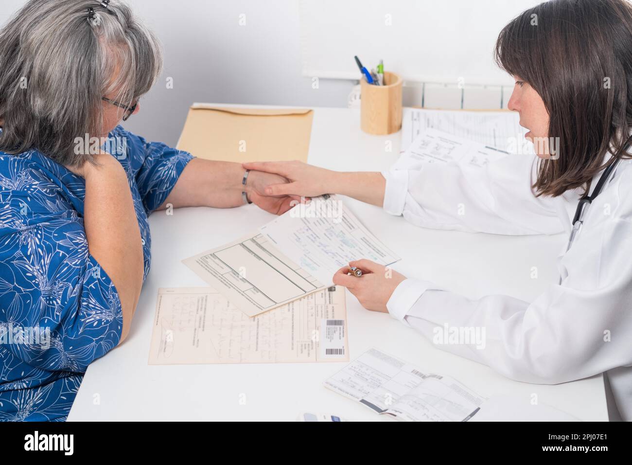 Young female doctor handing a prescription to her patient Stock Photo ...