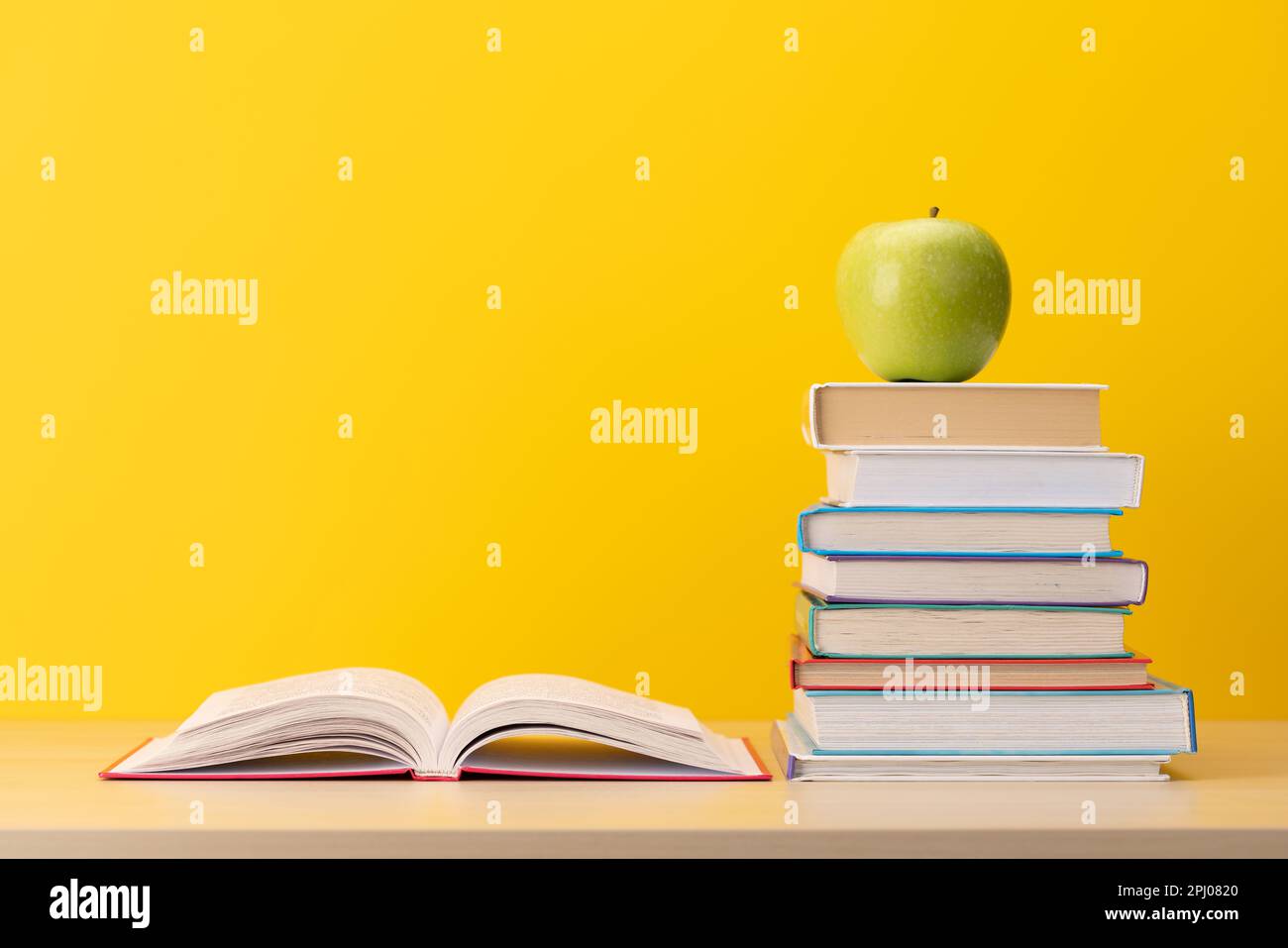 Stack of books on desk, apple and space for creativity Stock Photo - Alamy