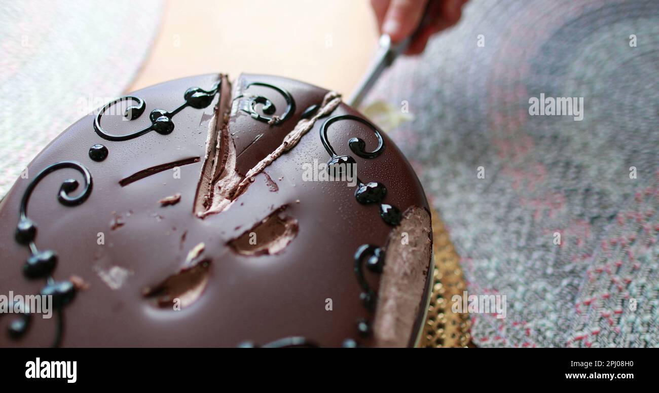 Cutting birthday cake slice, close-up of knife slicing chocolate cake ...