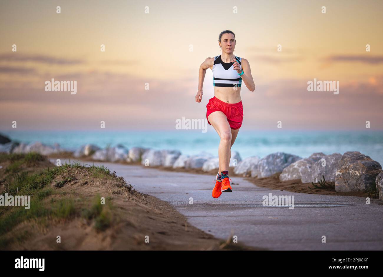 Woman running on a beautiful path with a sunset Stock Photo - Alamy