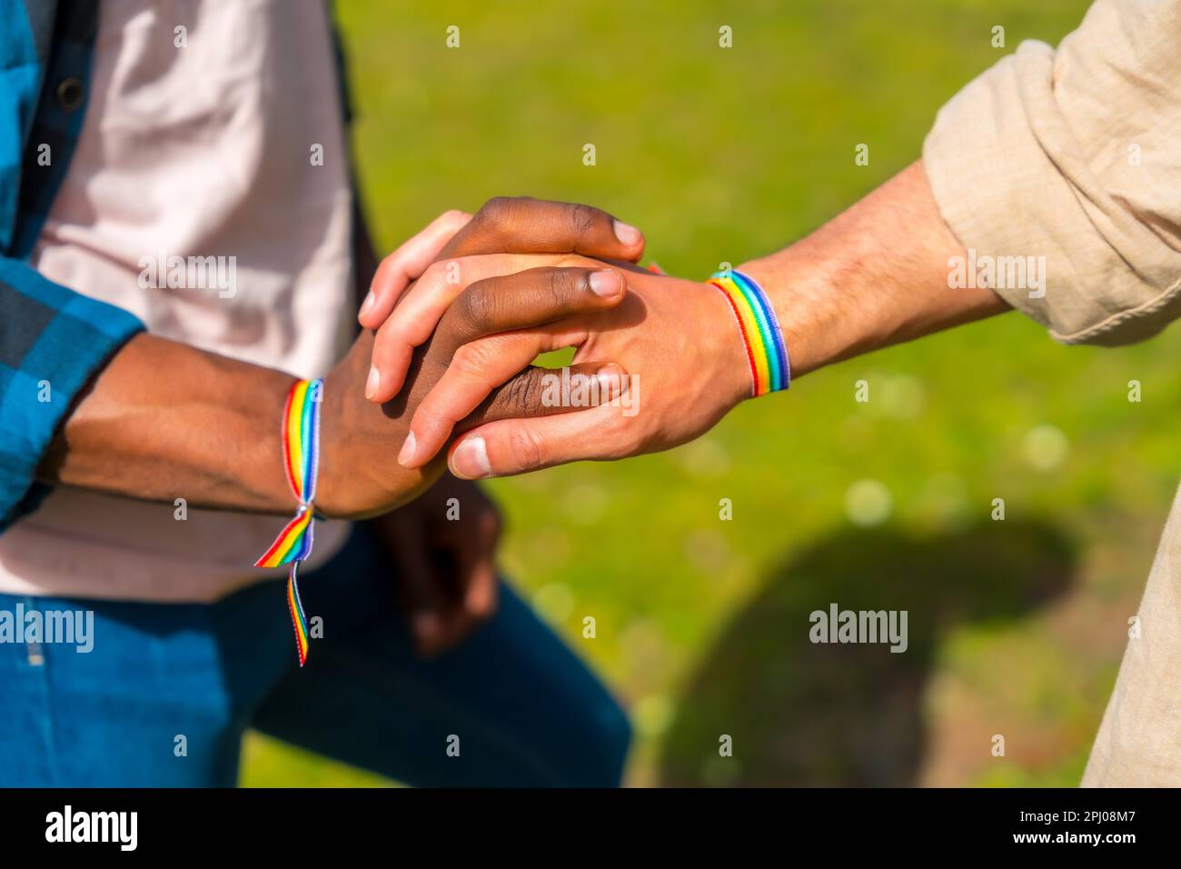 Hands of a multiethnic gay male couple holding hands, lgbt concept ...