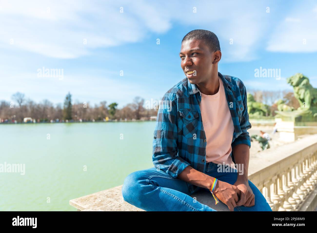 Portrait of a black ethnic man in summer by a lake carefree enjoying ...