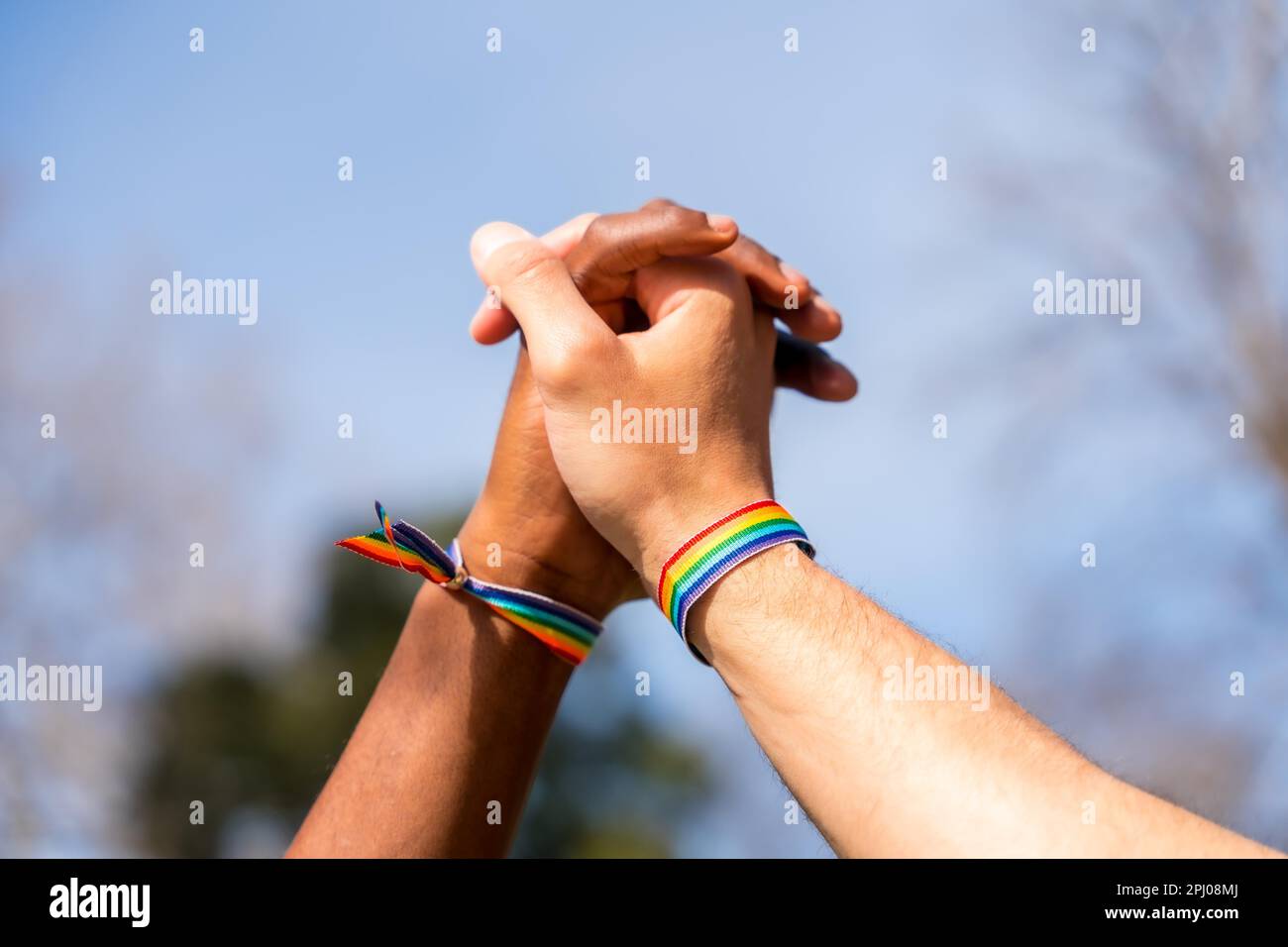 Hands of a multiethnic gay male couple holding hands, lgbt concept ...