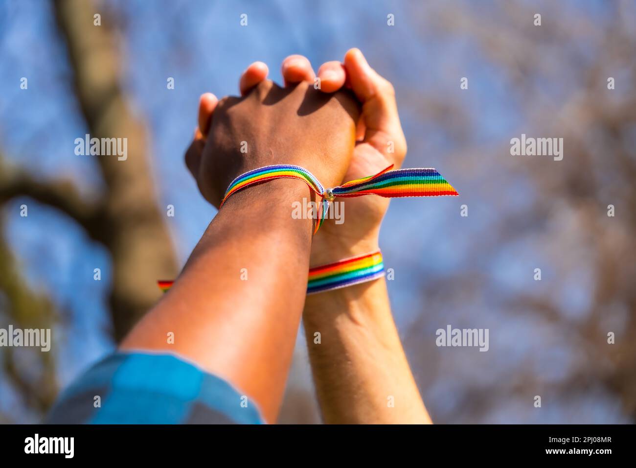Hands of a multiethnic gay male couple holding hands, lgbt concept ...