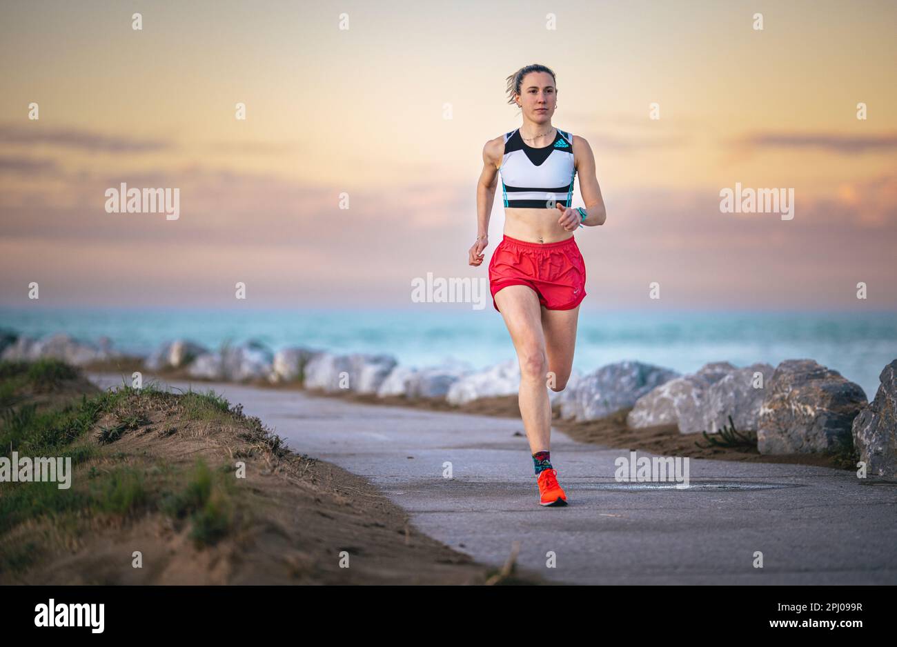 Woman running on a beautiful path with a sunset Stock Photo - Alamy
