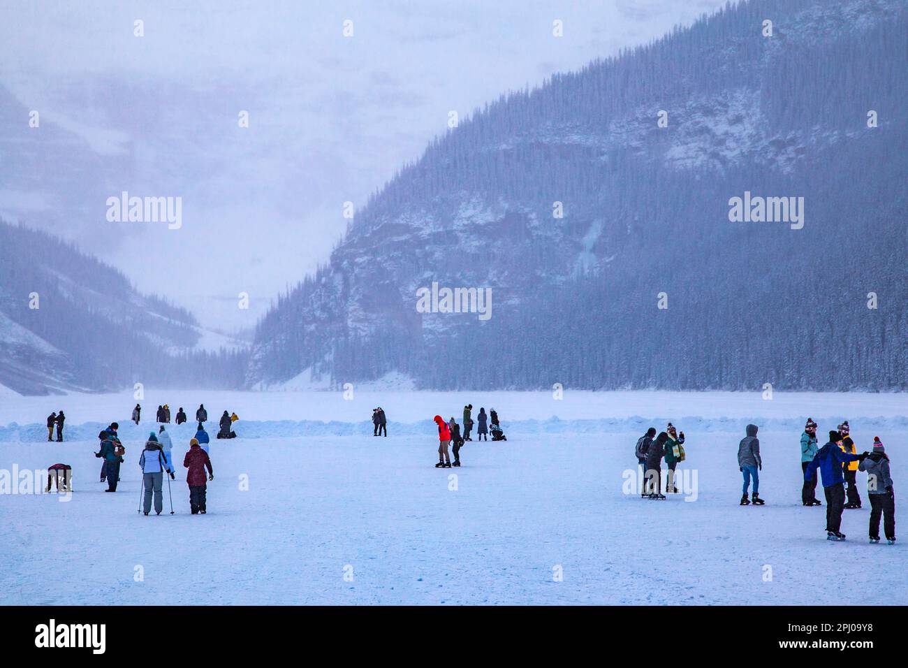 Ice skaters on the frozen mountain lake Lake Louise near Castle Hotel ...