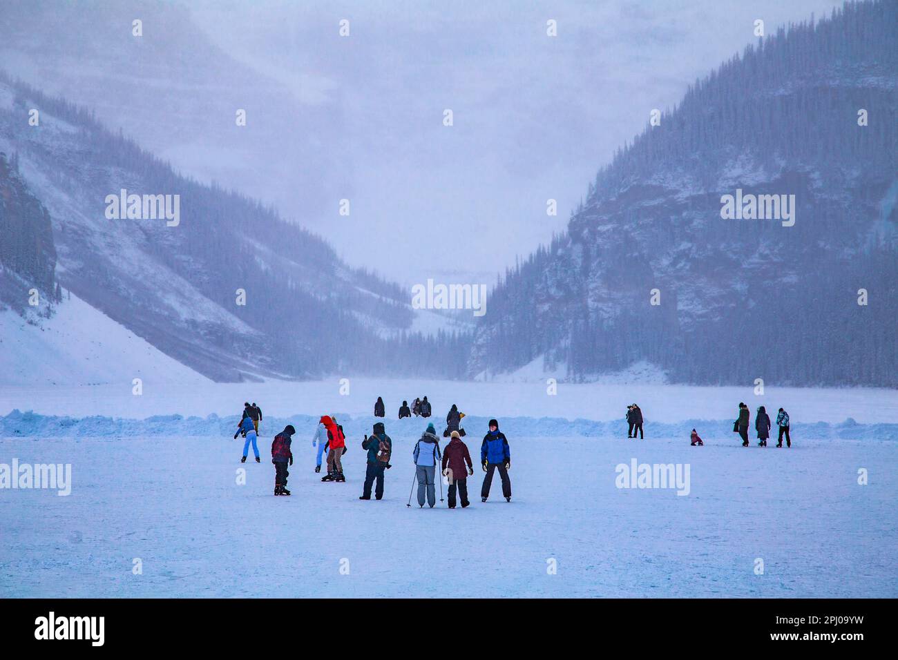Ice skaters on the frozen mountain lake Lake Louise near Castle Hotel Chateau Lake Louise ...