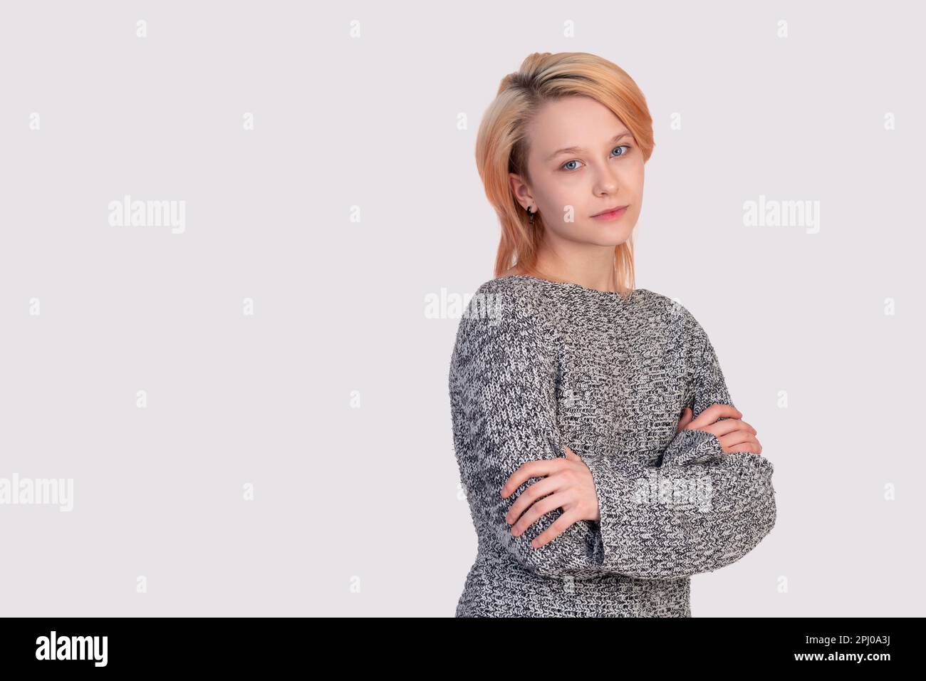 girl teenager in a closed position looks into the frame isolated on a ...