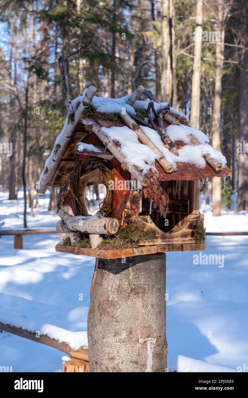 bird feeder made of natural materials is set in a winter snowy forest ...