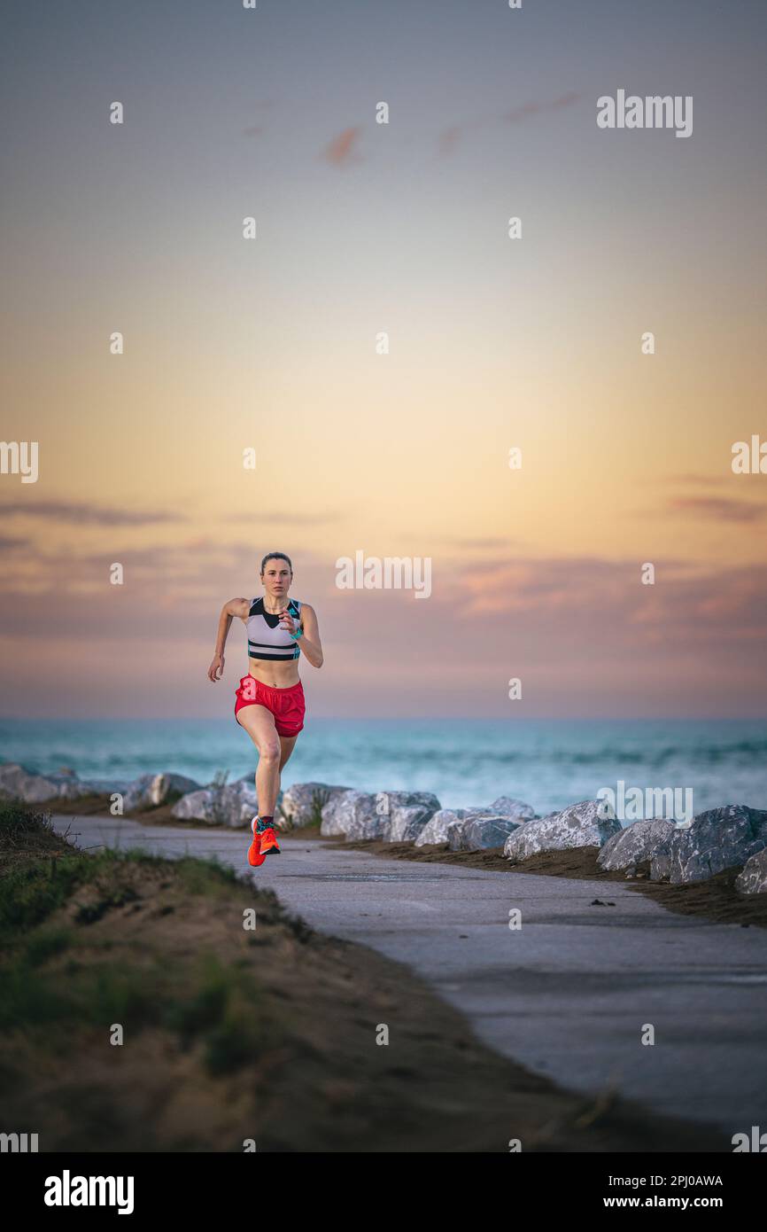 Woman running on a beautiful path with a sunset Stock Photo - Alamy