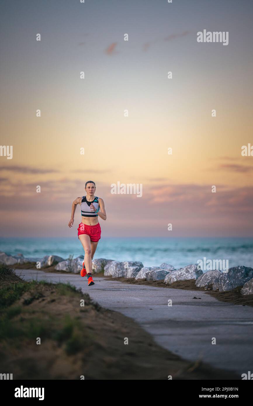Woman running on a beautiful path with a sunset Stock Photo - Alamy