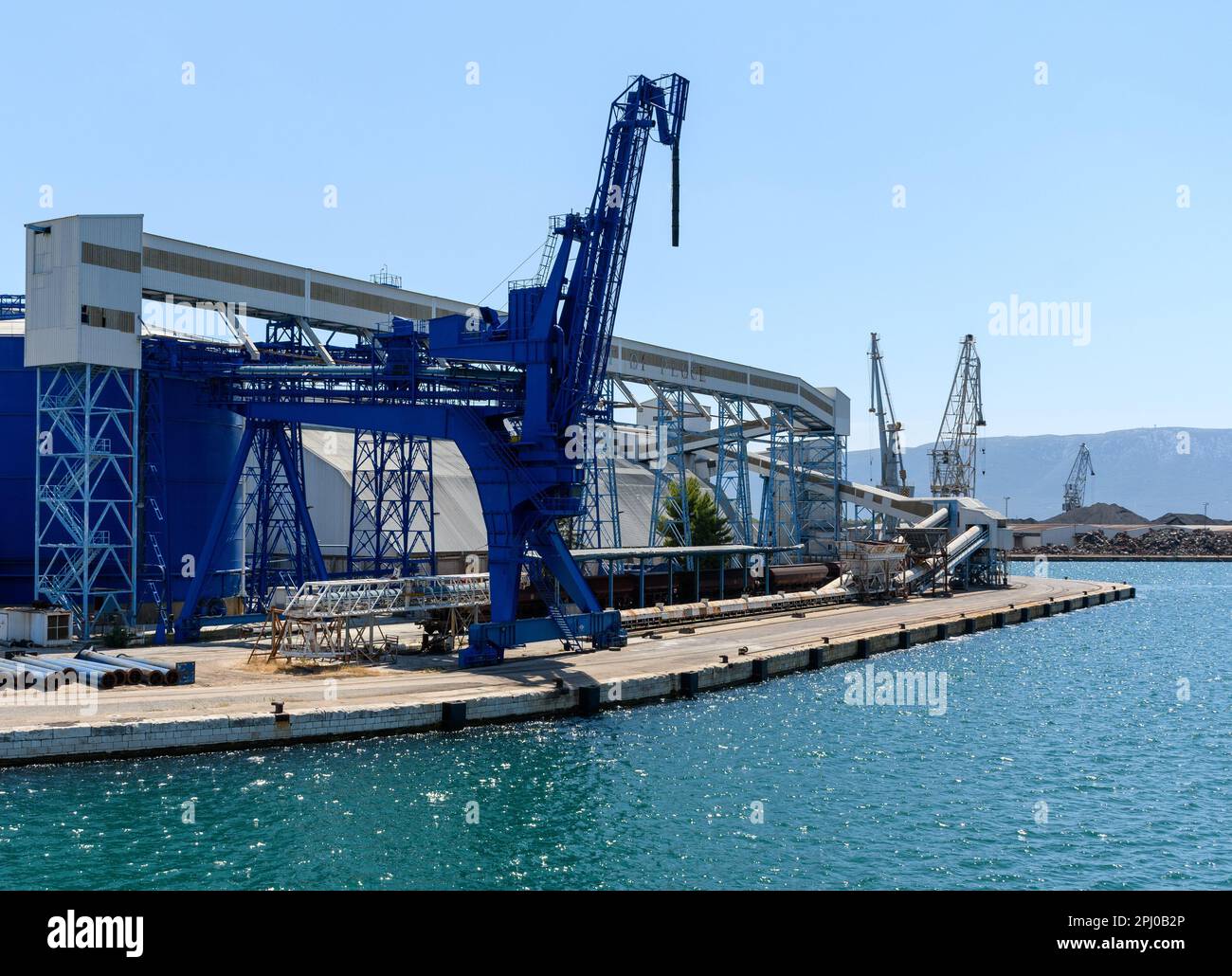 Large industrial machinery for loading cargo on trains on a sunny dock ...