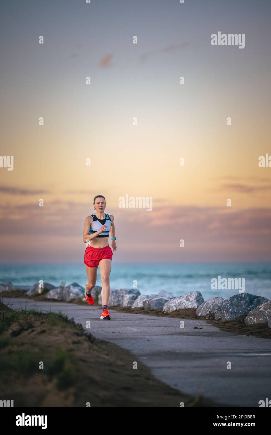 Woman running on a beautiful path with a sunset Stock Photo - Alamy
