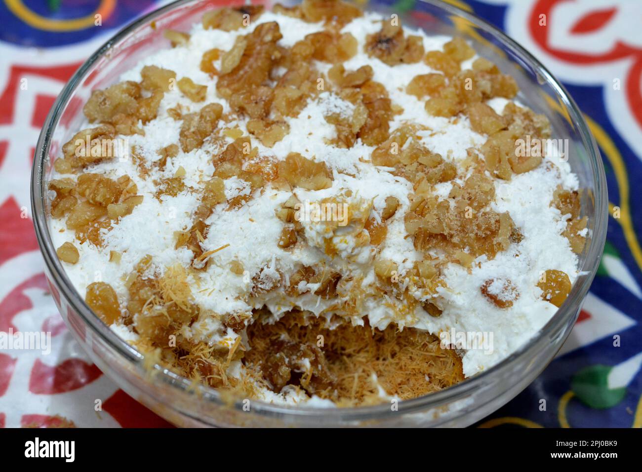 Konafa topped with whipped cream, raisins, walnuts, shredded coconut ...