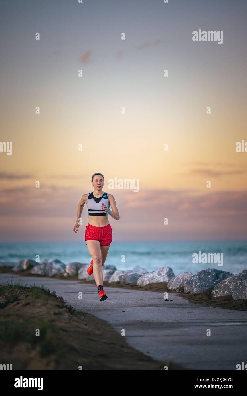 Woman running on a beautiful path with a sunset Stock Photo - Alamy
