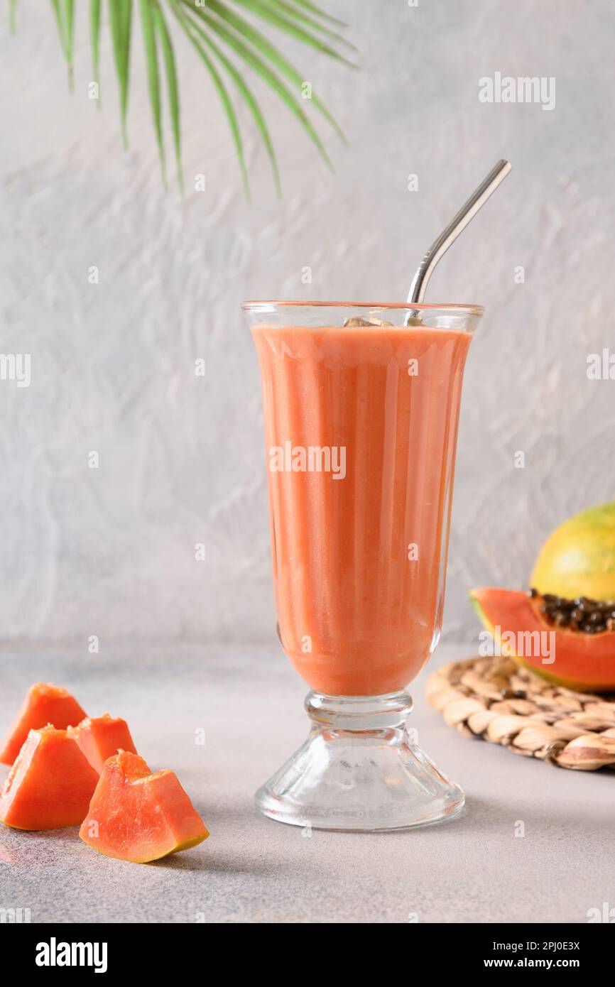 One glass of Papaya smoothie or lassi on light gray background ...