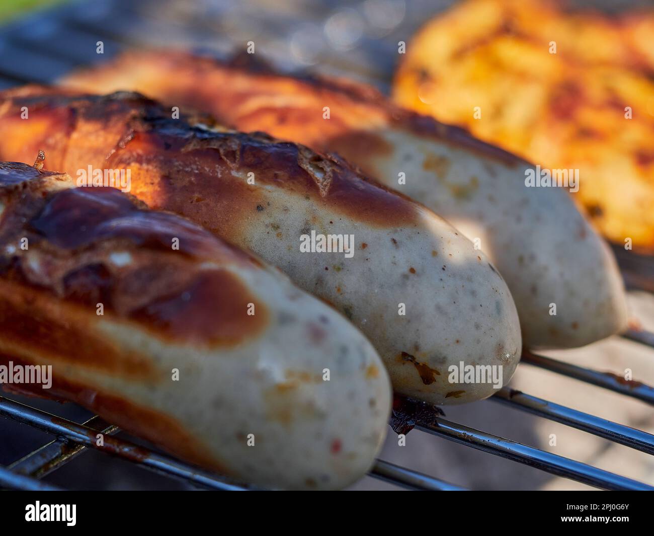 german bratwurst pork sausage cooking on a barbecue grill over open ...