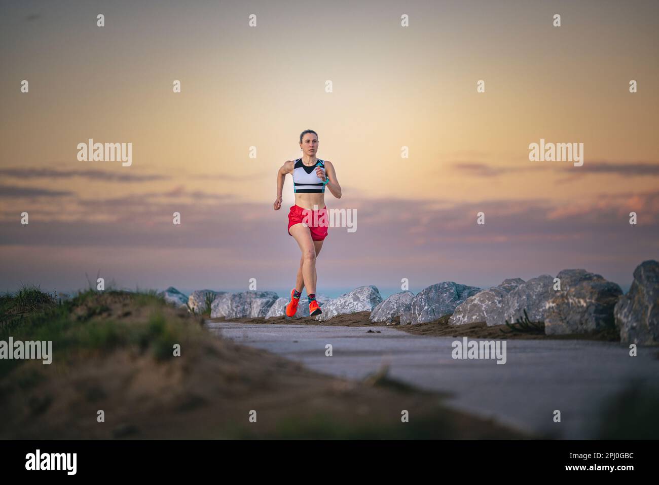 Woman running on a beautiful path with a sunset Stock Photo - Alamy