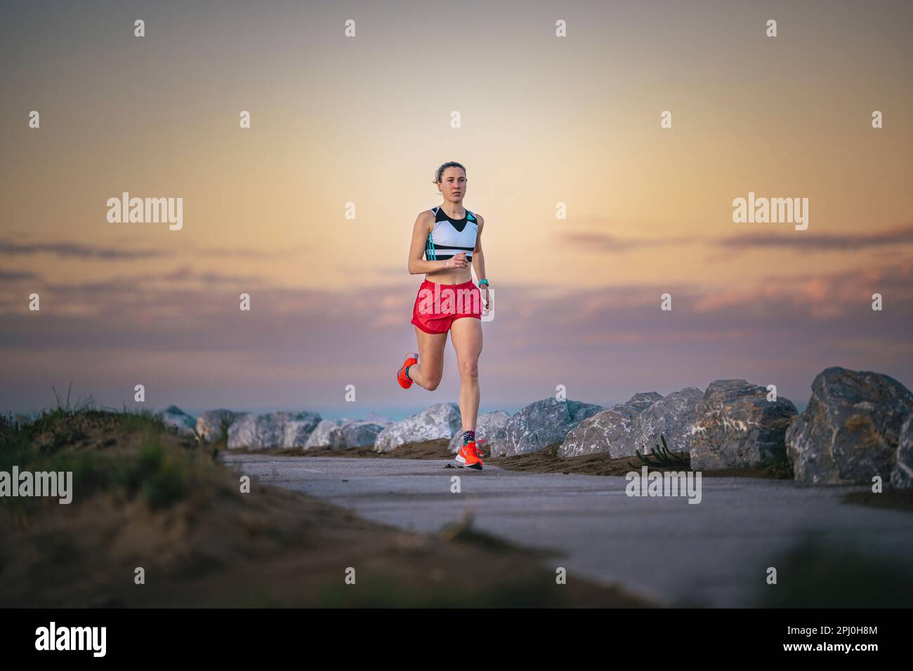 Woman running on a beautiful path with a sunset Stock Photo - Alamy