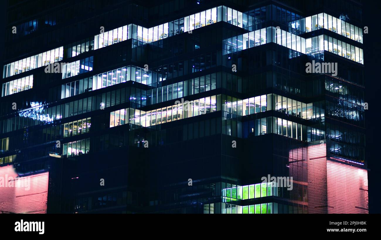 Pattern of office buildings windows illuminated at night. Glass ...