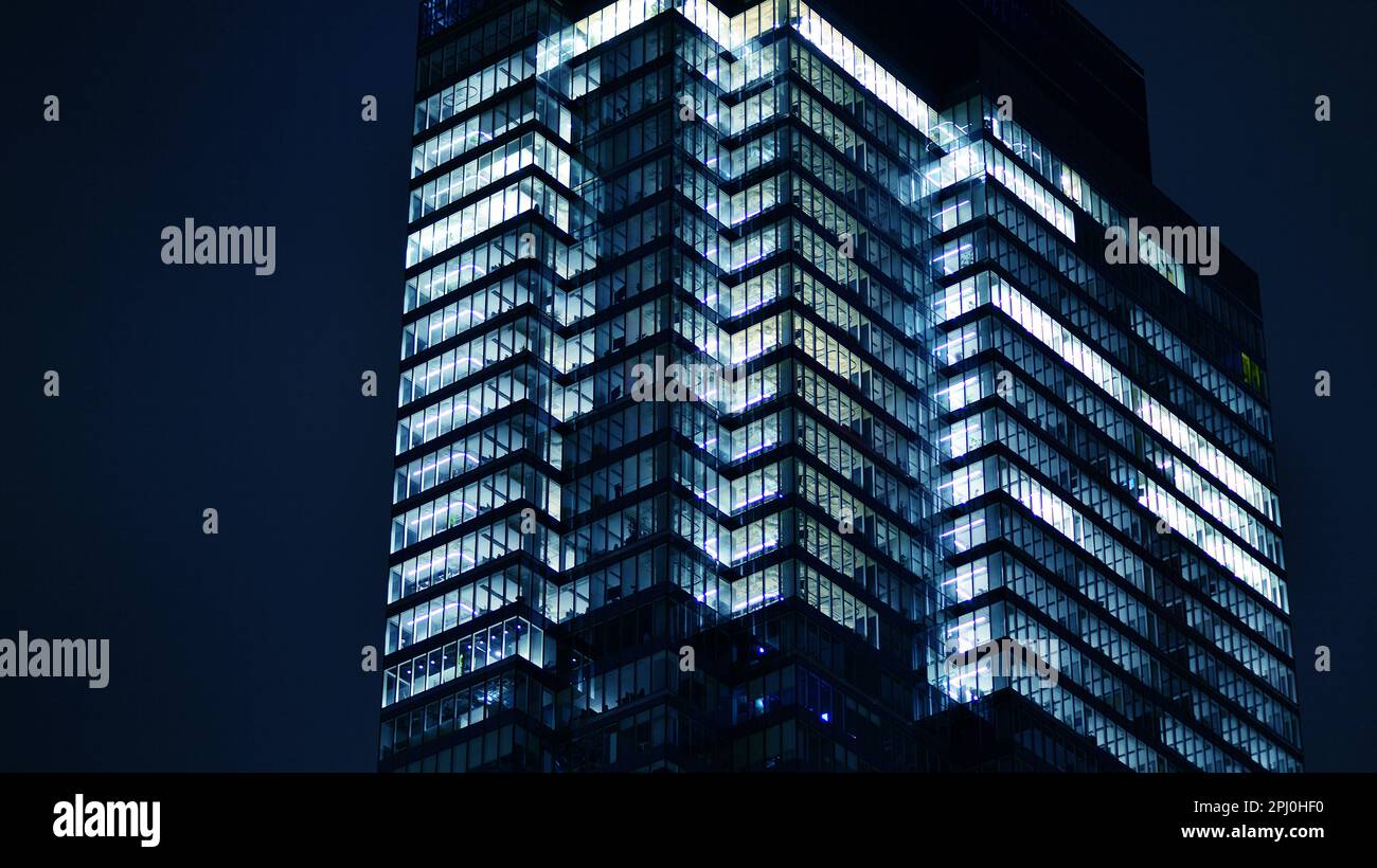Pattern of office buildings windows illuminated at night. Glass ...