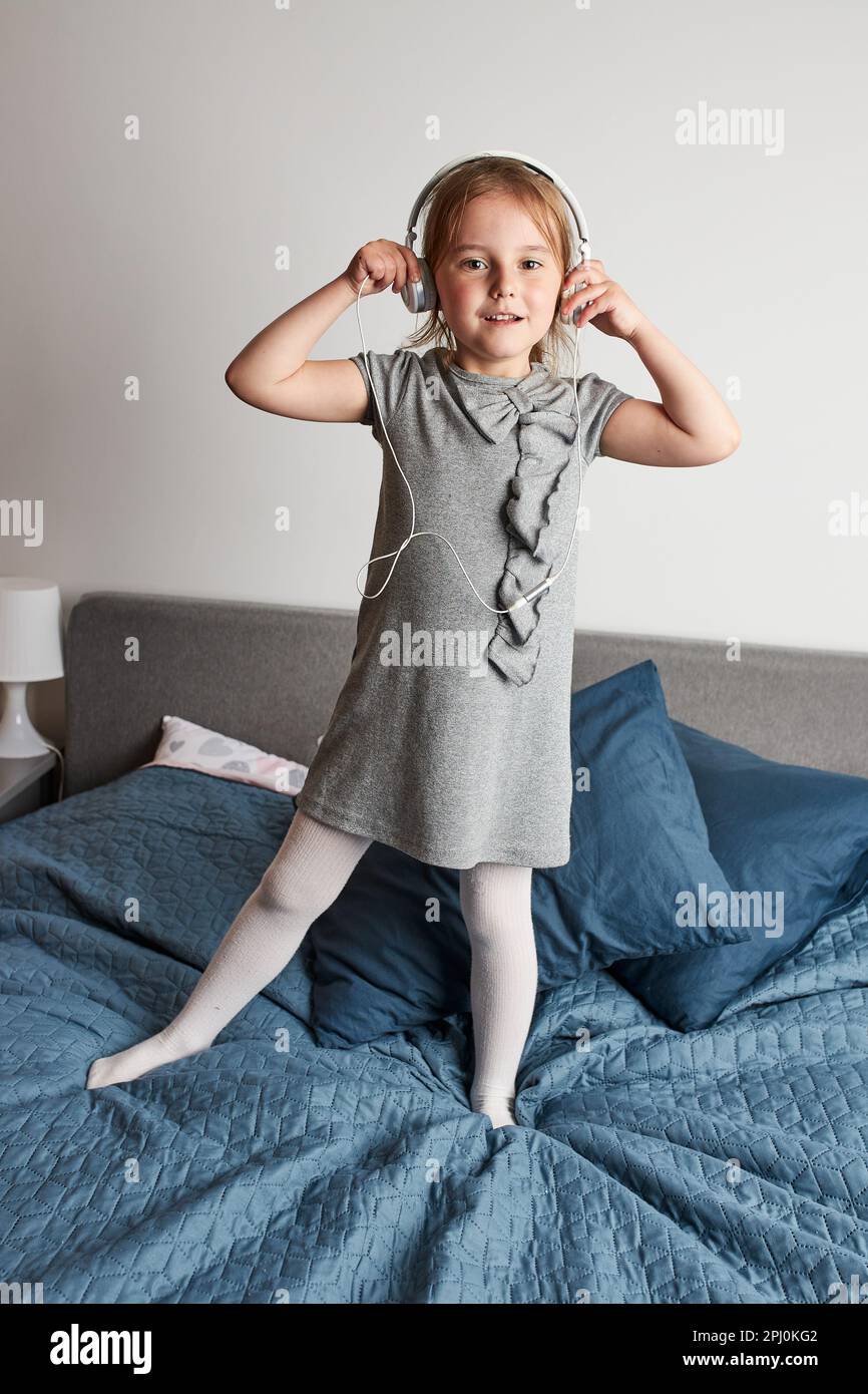 Little girl singing holding headphones cord imitating herself a real ...