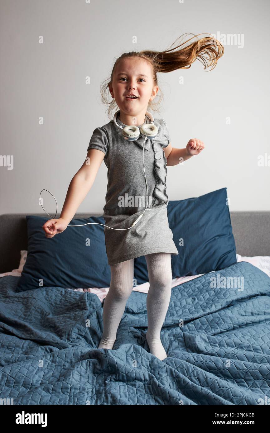 Little girl singing holding headphones cord imitating herself a real ...