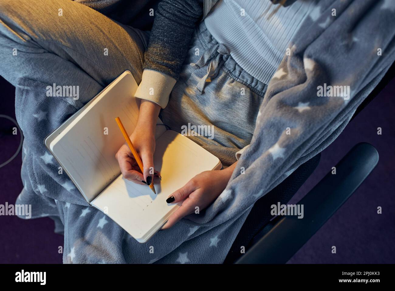 Student learning at home. Young woman making notes, reading and ...