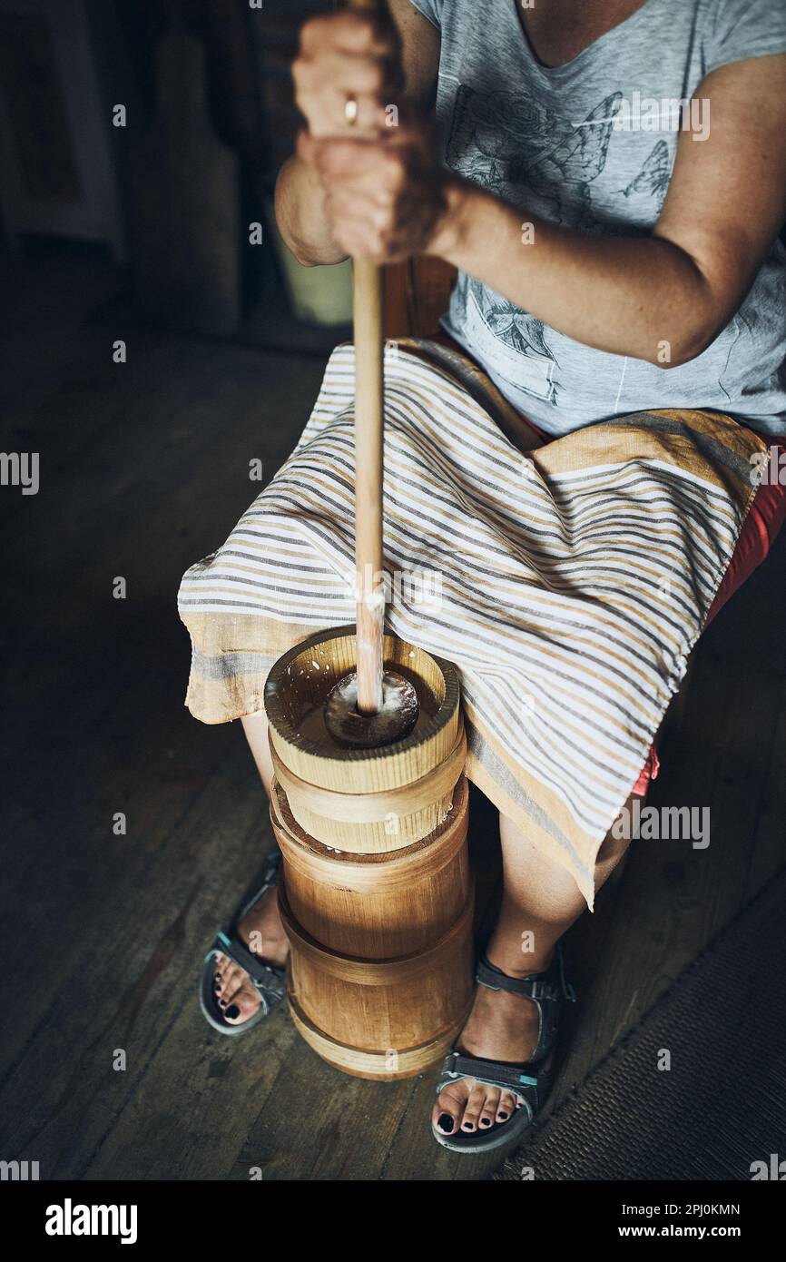 Woman making butter with butter churn. Old traditional method making of ...