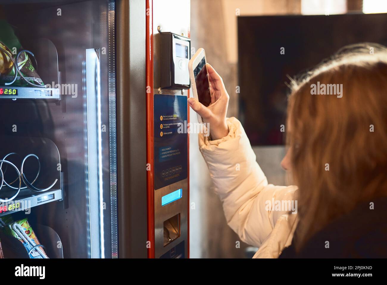 Woman paying for product at vending machine using contactless method of ...