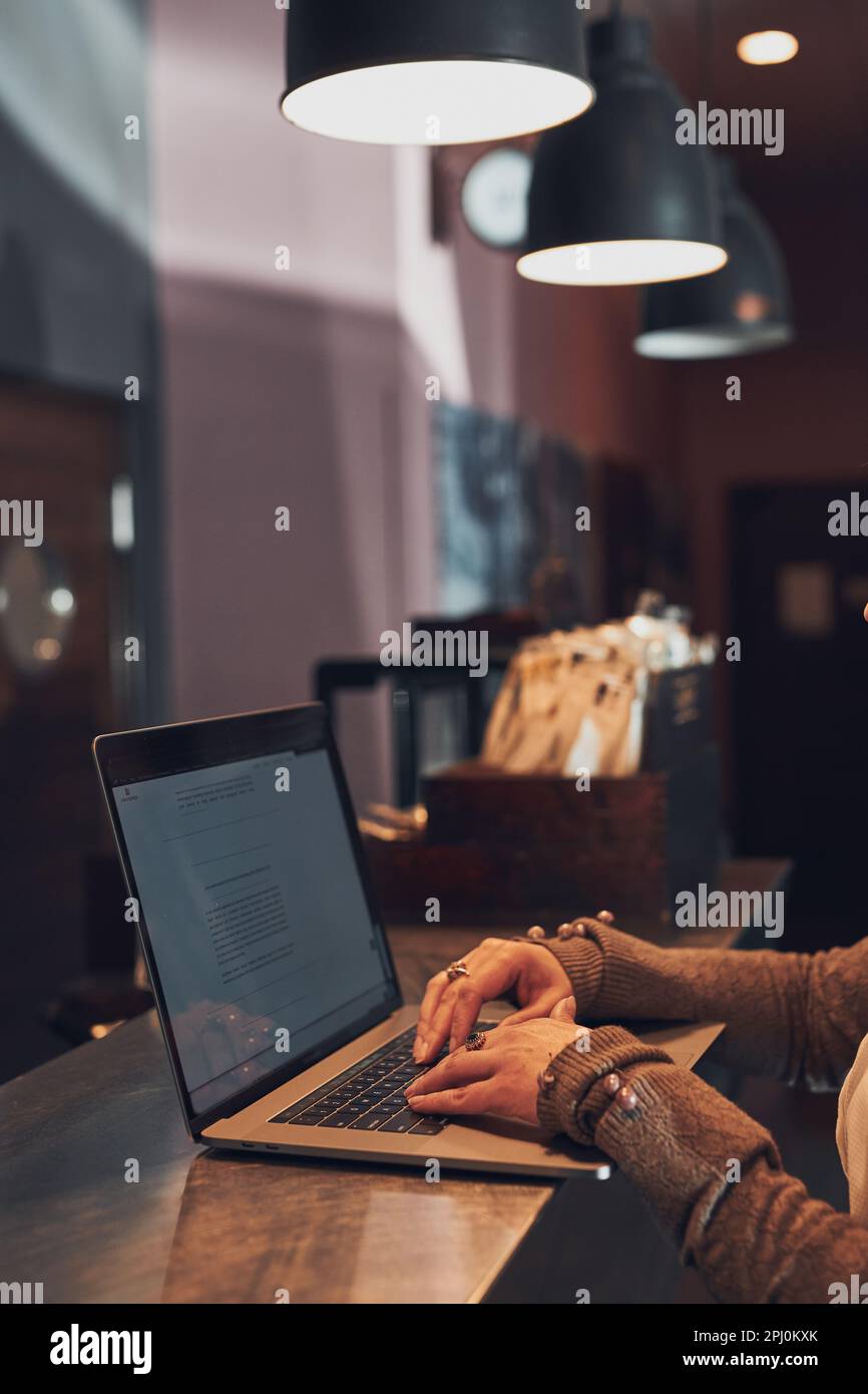 Woman working remotely on her laptop computer managing her work sitting ...