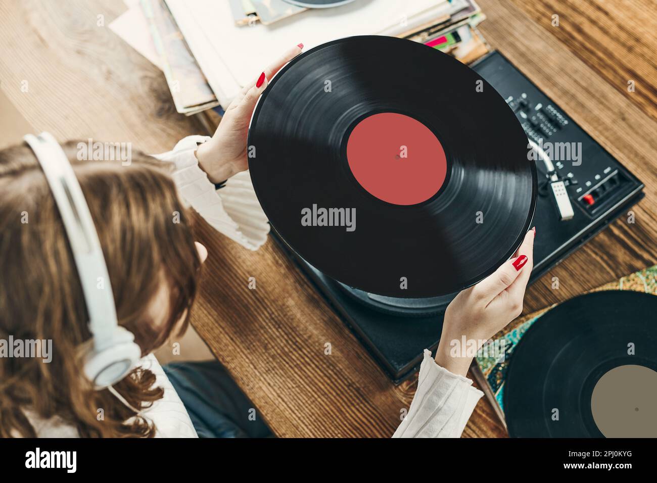 Young woman listening to music from vinyl record player. Playing music ...