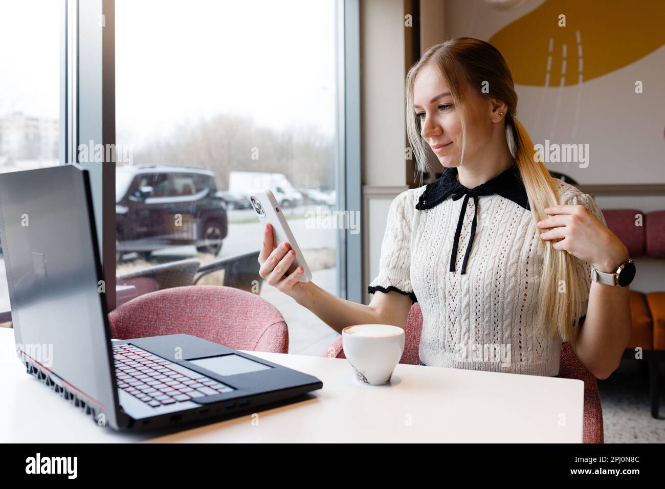 A girl works at a computer in a coffee shop Stock Photo - Alamy