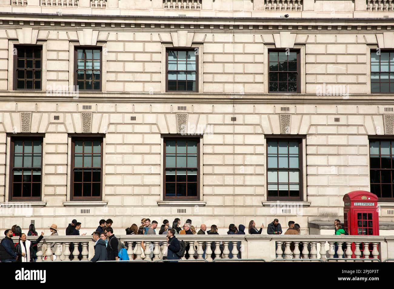 People queue to take photographs next to a red telephone box in ...