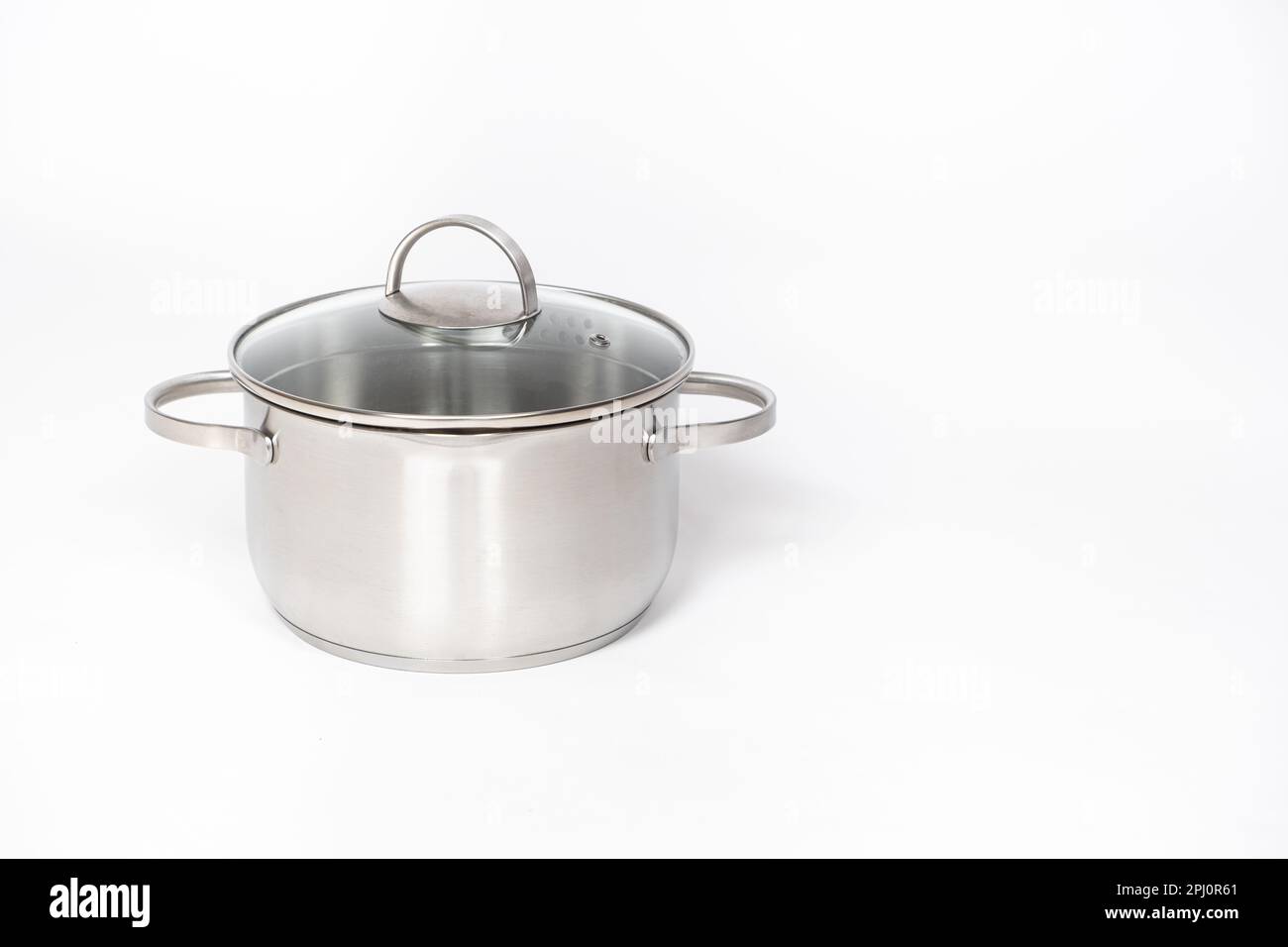 Stainless steel pot with glass lid and drain spout on a white ...