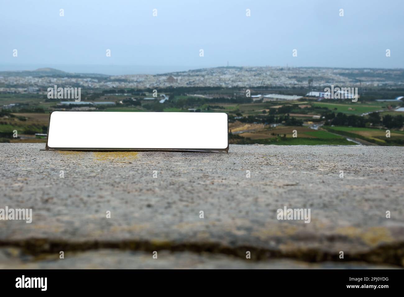 Empty sign on top of a stone wall with rural landscape in the ...
