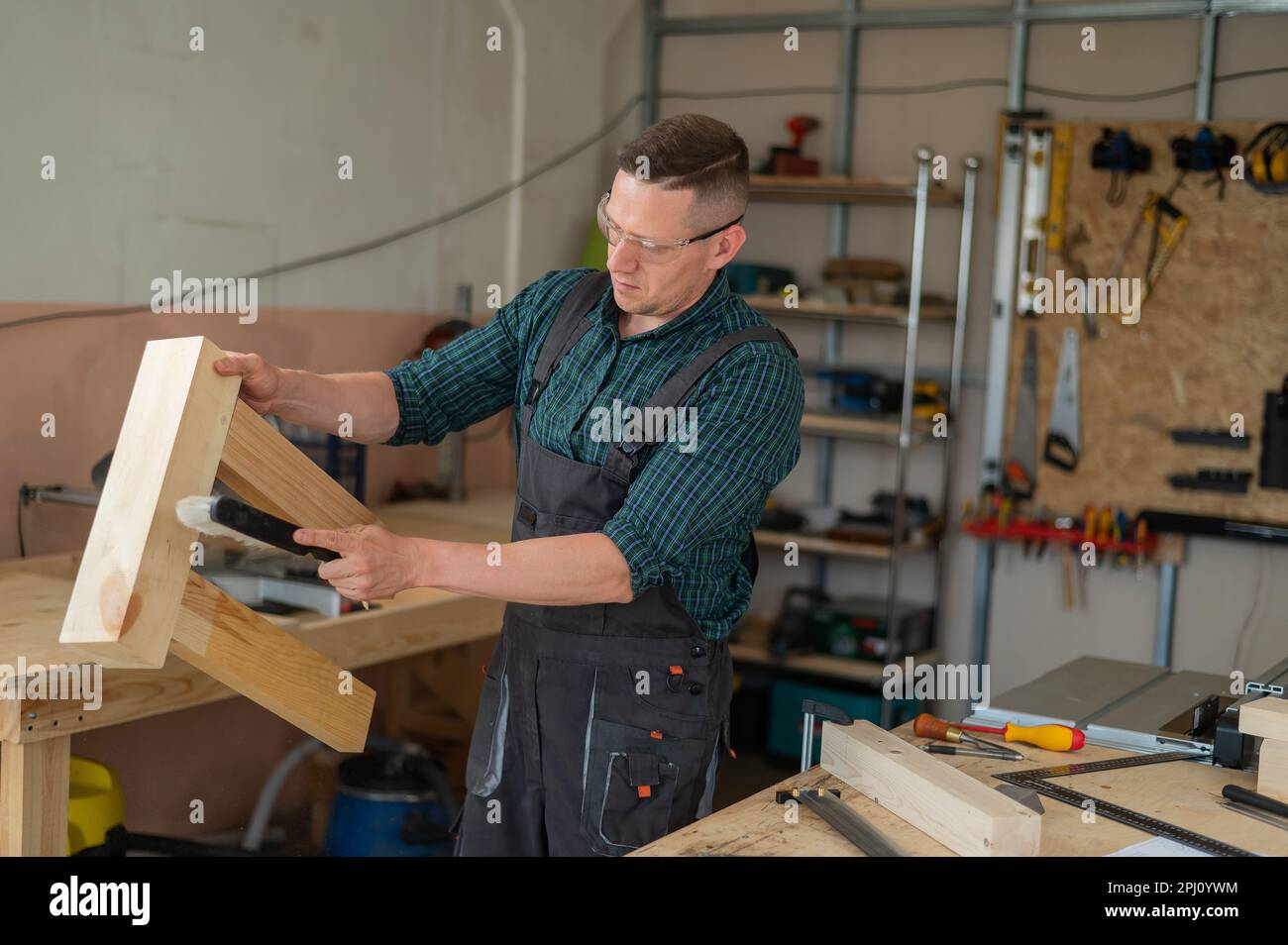 The carpenter shakes off sawdust from a wooden product Stock Photo - Alamy