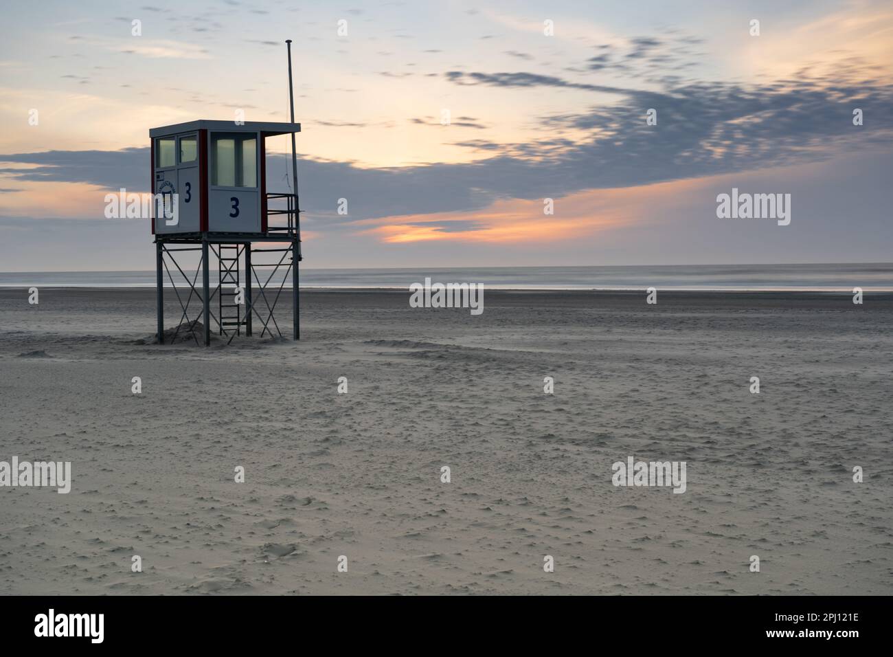A lifeguard tower standing on the beachfront overlooking the vast ocean ...
