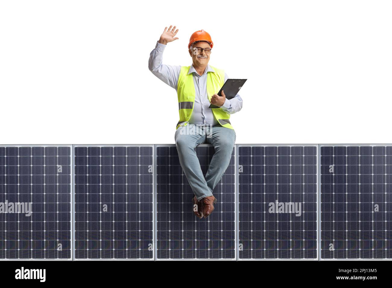 Mature male engineer sitting on a solar panel and waving isolated on ...