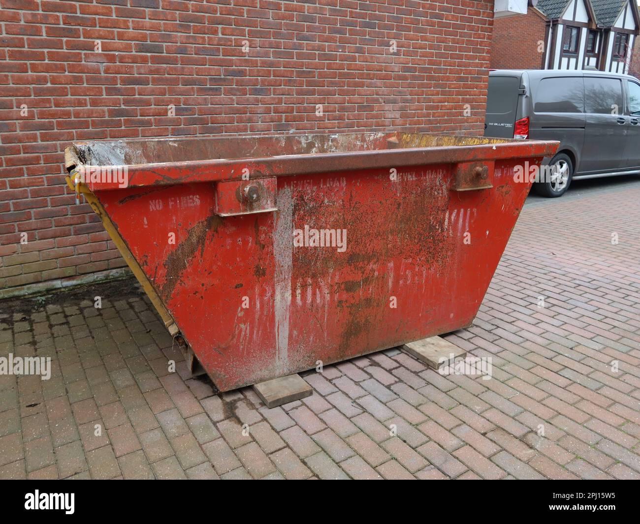 Suffolk, UK March 2023 : Small empty orange skip on a driveway Stock ...