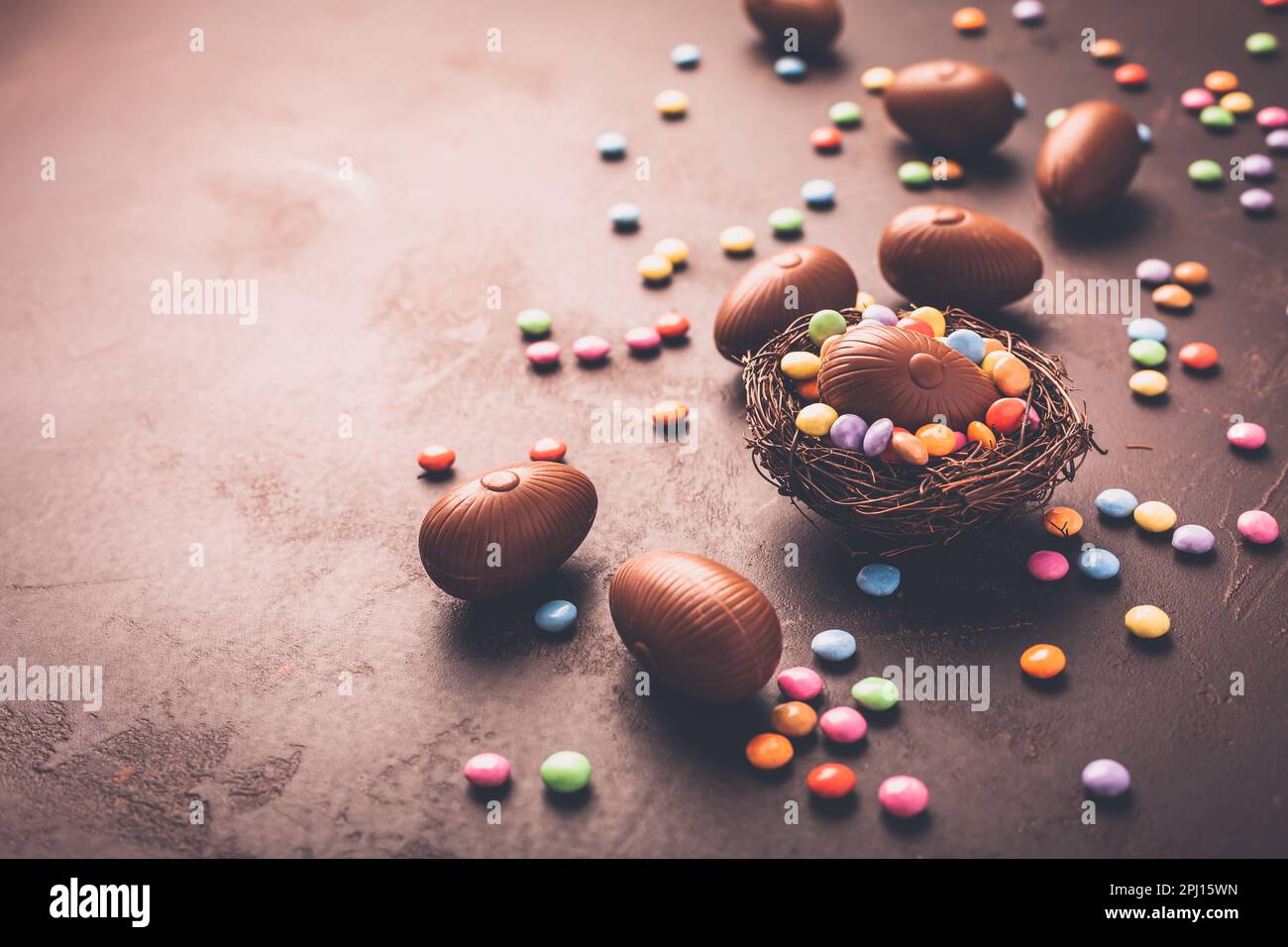 Sweet Easter - Chocolate eggs and colorful chocolate beans in bird nest ...