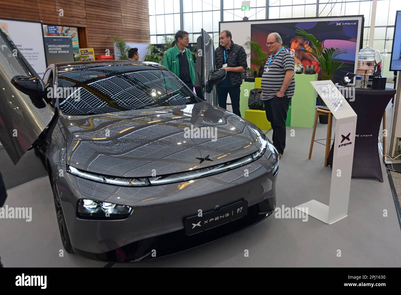 People lookin at a XPeng Motors electric car on display at the World of ...